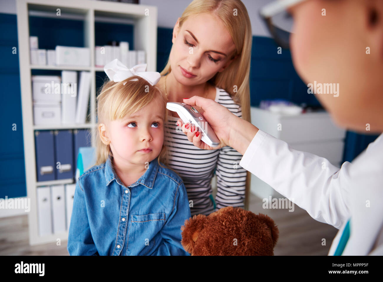 Doctor taking girl's temperature in medical practice Stock Photo - Alamy