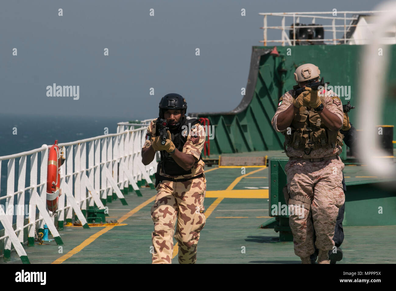 Two Kuwaiti special operations troops search an oil tanker somewhere in ...