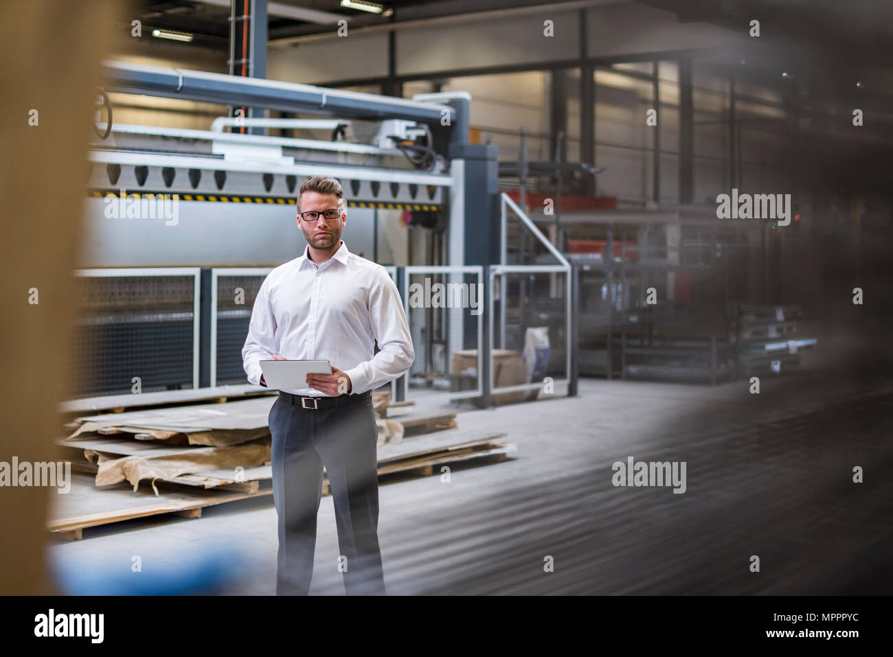 Businessman using tablet on factory shop floor Stock Photo - Alamy