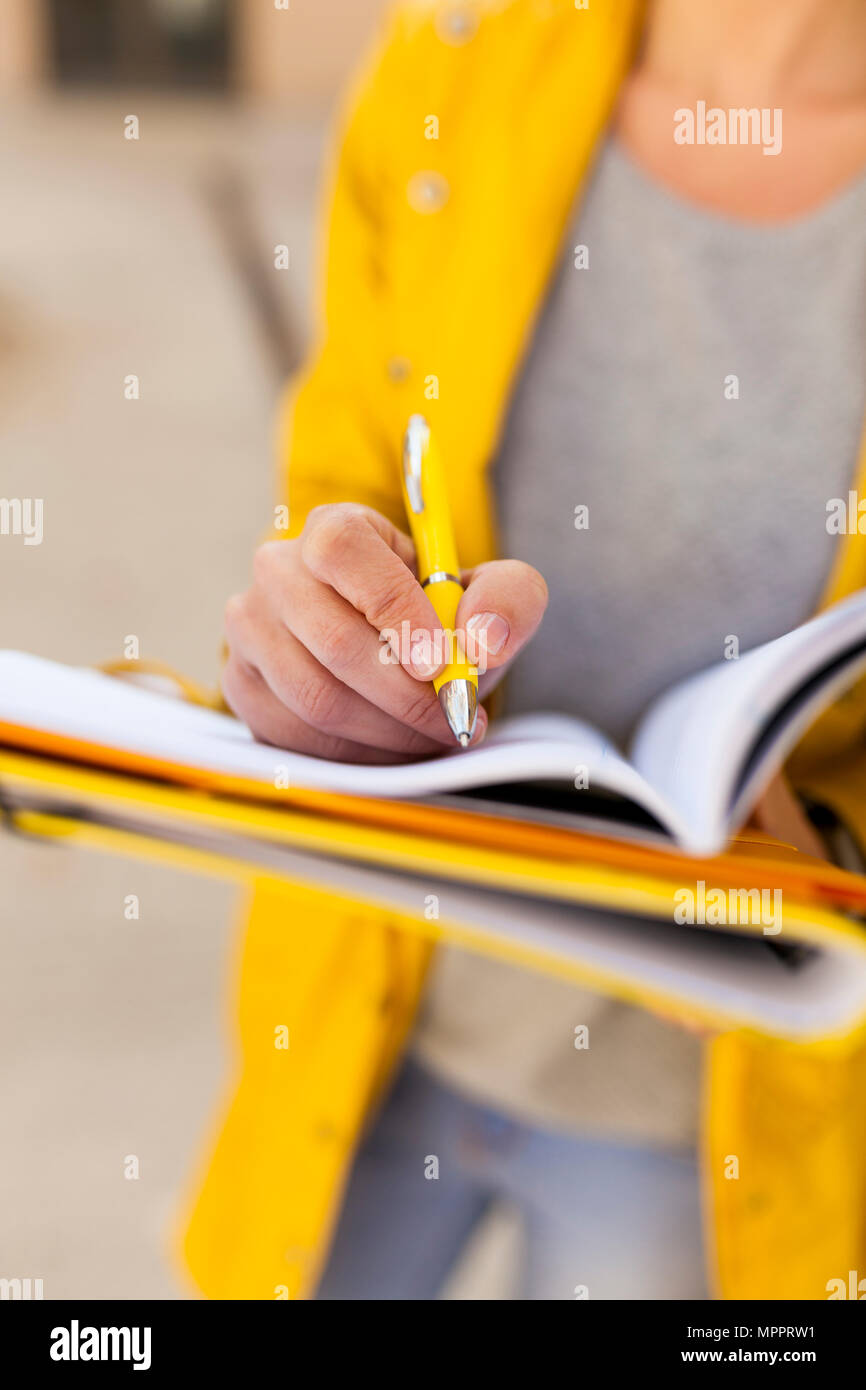 Close-up of woman taking notes outdoors Stock Photo - Alamy