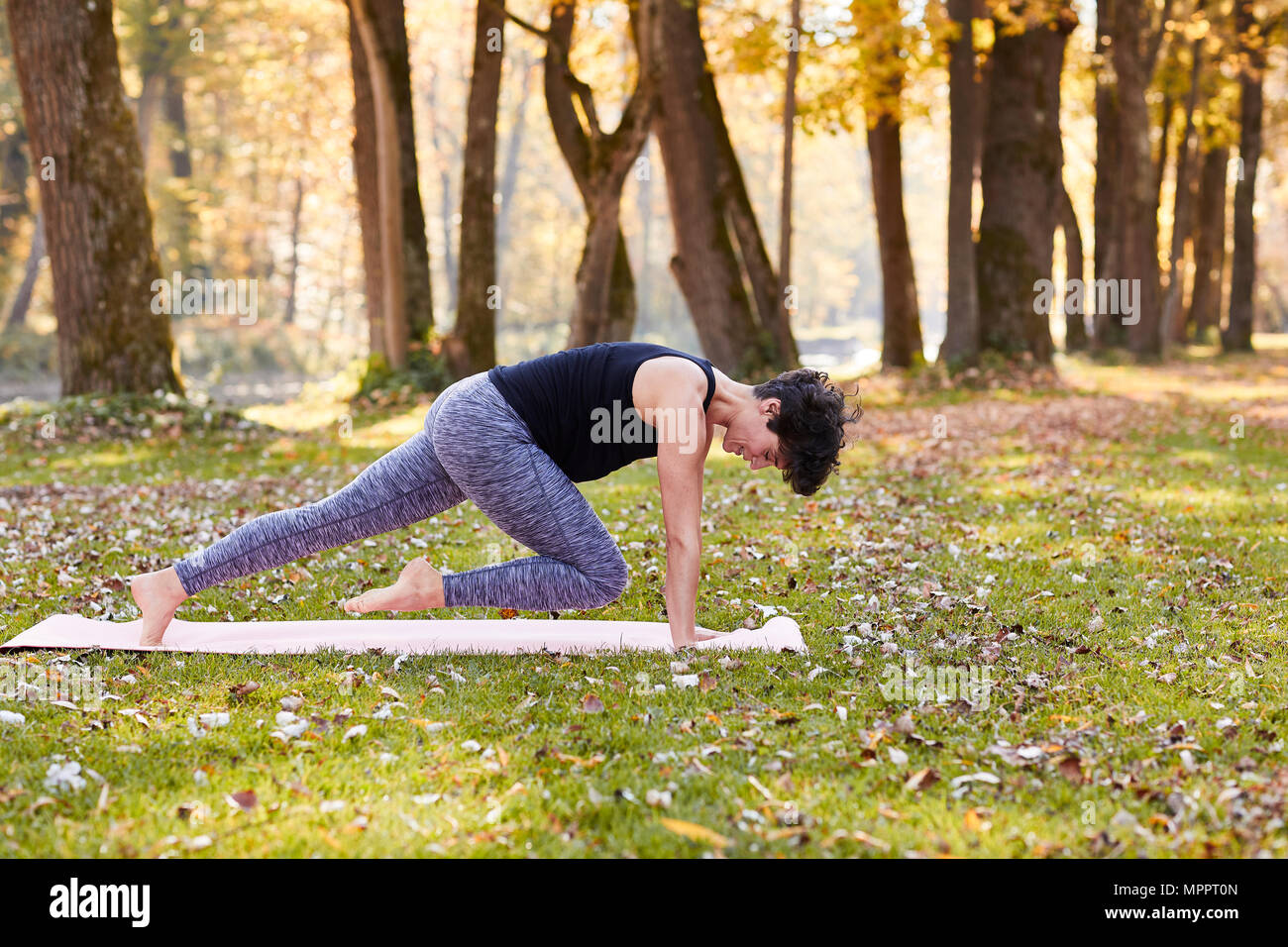 Mid adult woman in forest practicing yoga, climber exercise Stock Photo ...