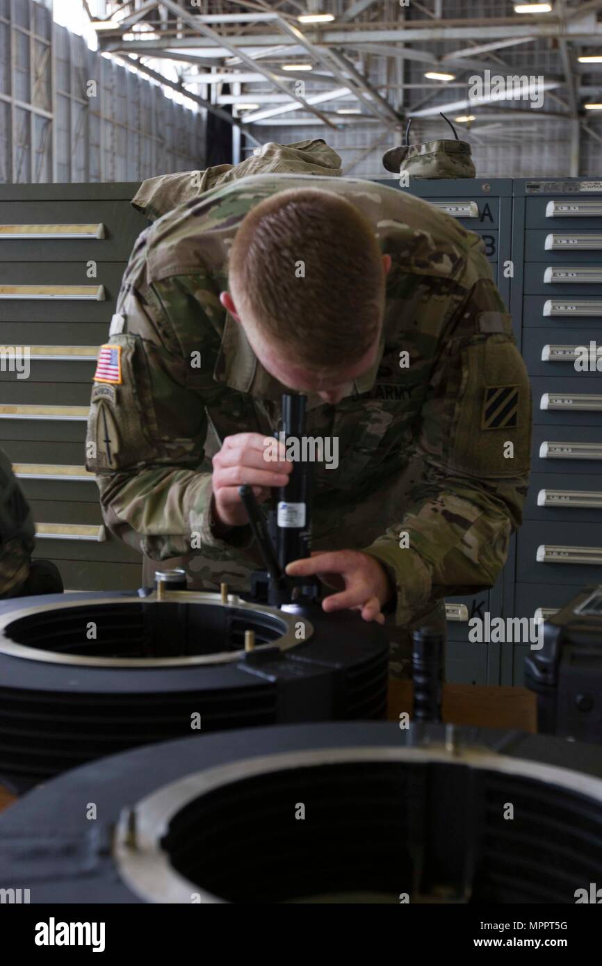 A Soldier looks through a digital micrometer to ensure a part of the CH ...