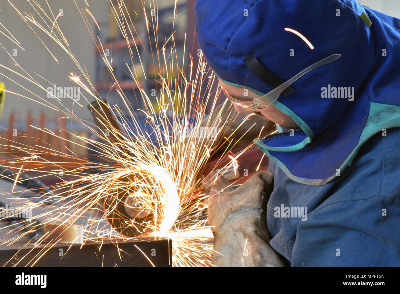 Worker using angle grinder in factory Stock Photo - Alamy