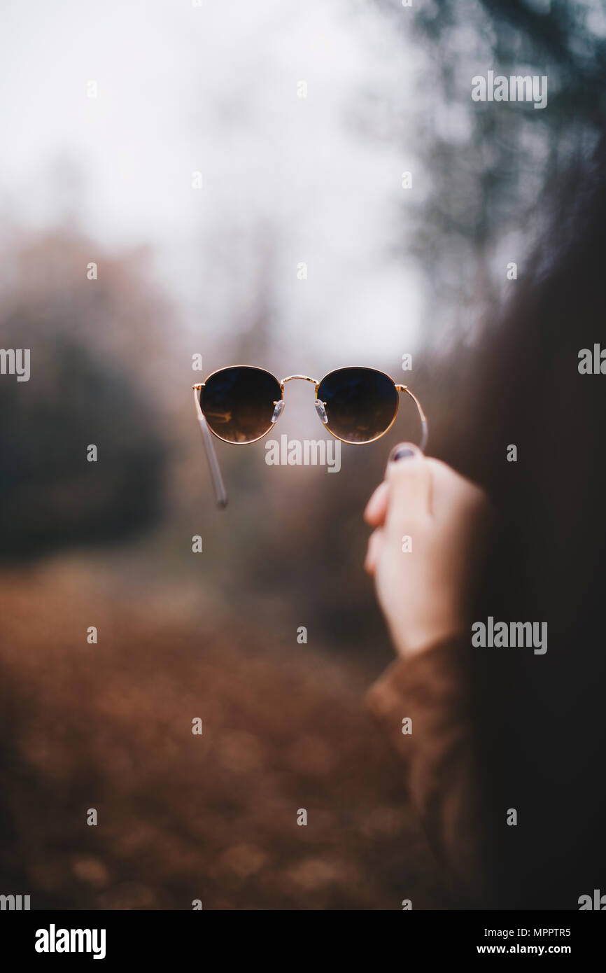 Woman's hand holding sunglasses Stock Photo - Alamy