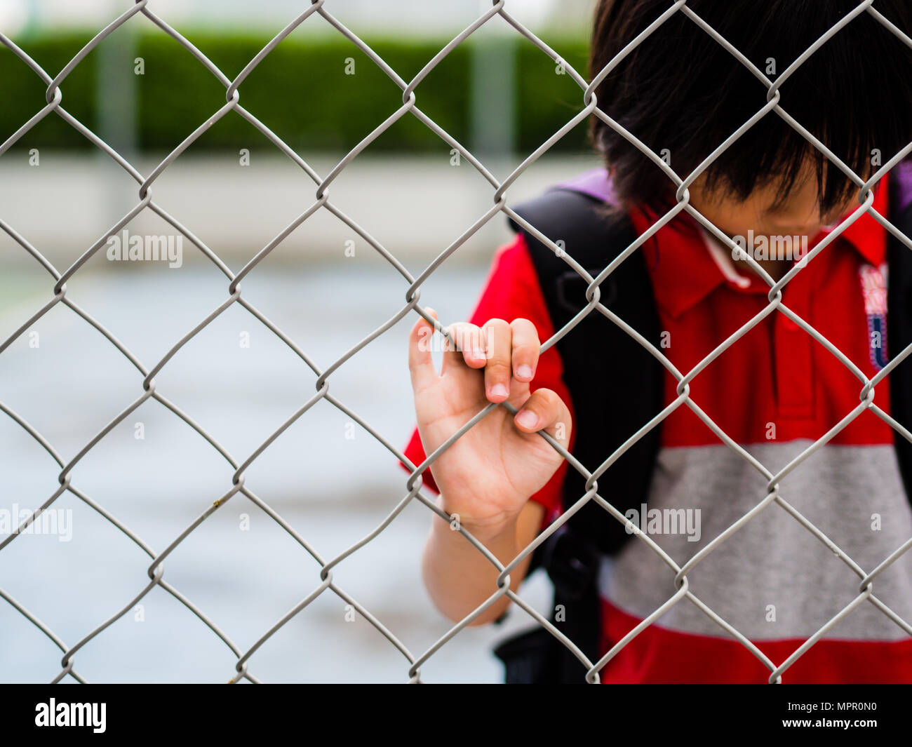 Portrait sad boy behind fence mesh netting. Emotions concept - sadness ...