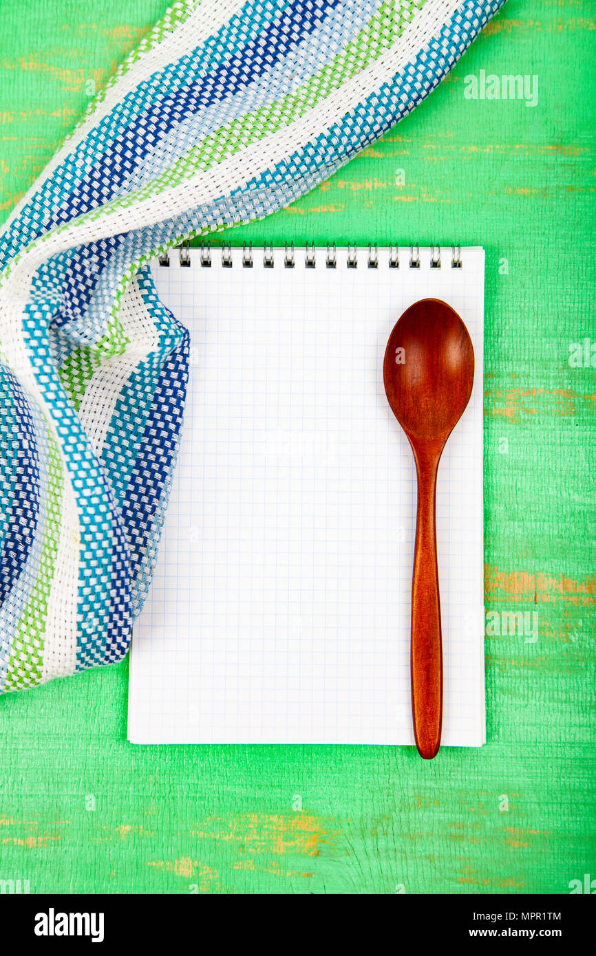 Culinary recipe, towel and spoon on a green wooden table. Cooking. Menu ...