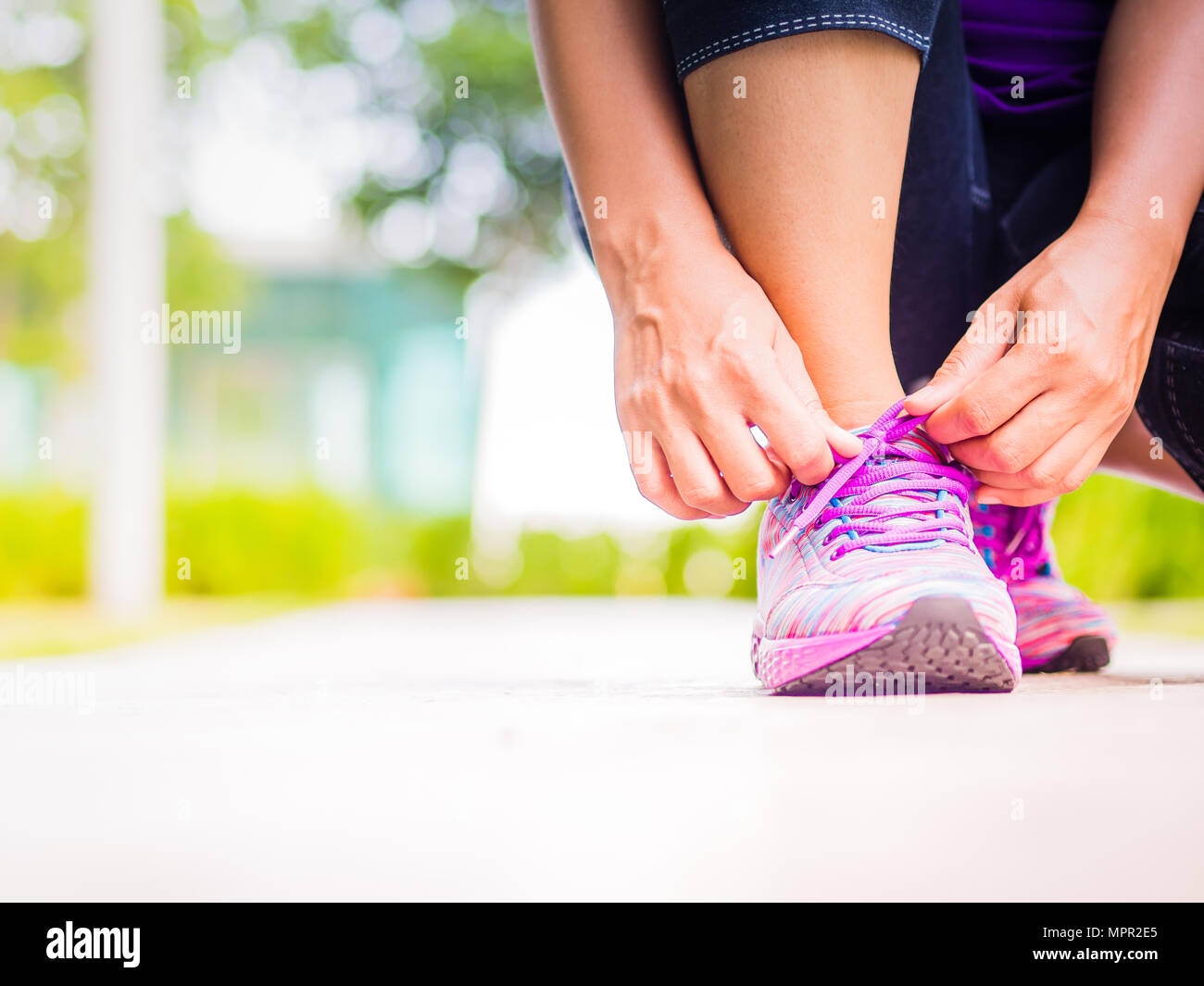 Running shoes - closeup of woman tying shoe laces. Female sport fitness runner getting ready for ...