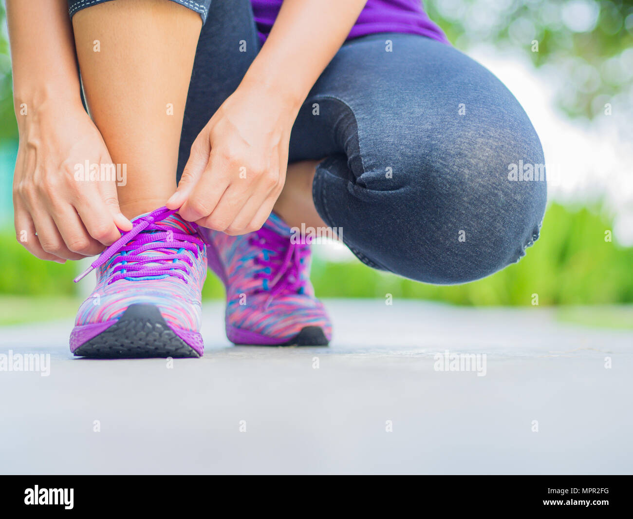 Running shoes - closeup of woman tying shoe laces. Female sport fitness runner getting ready for ...