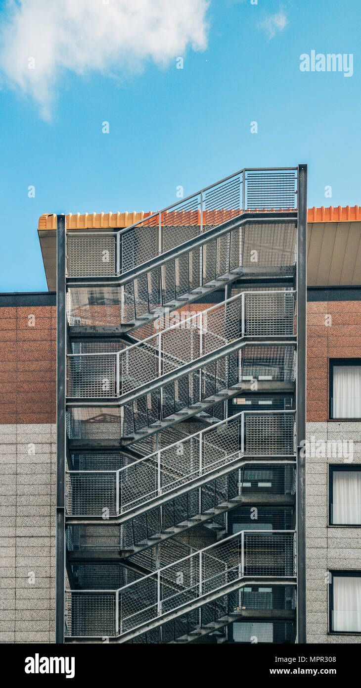 Escape stairs escape route on side of office building with blue sky ...