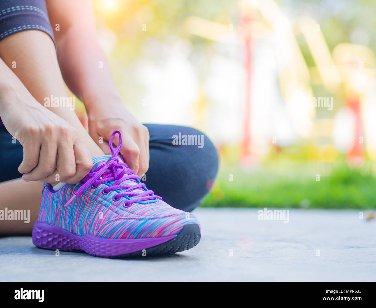 Running shoes - closeup of woman tying shoe laces. Female sport fitness runner getting ready for ...