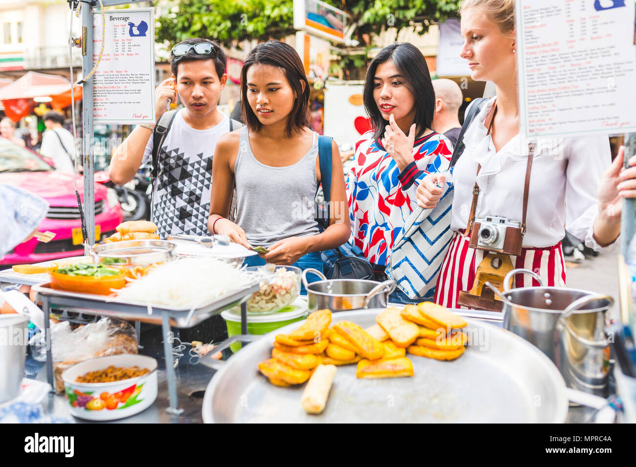 Thailand, Bangkok, Khao San Road, group of friends choosing local food ...