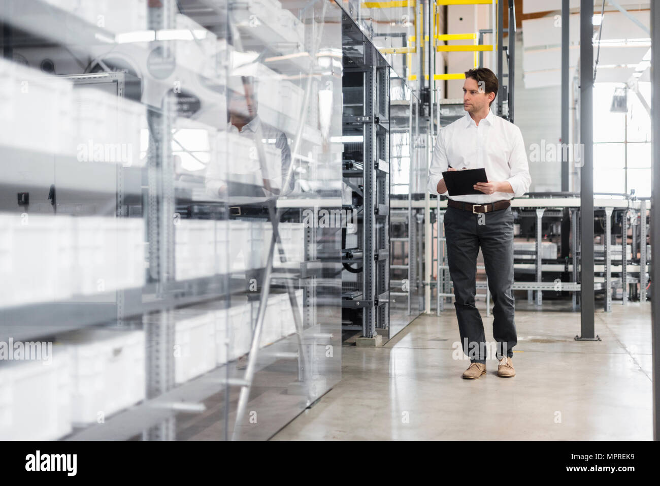 Man with clipboard in modern factory Stock Photo - Alamy