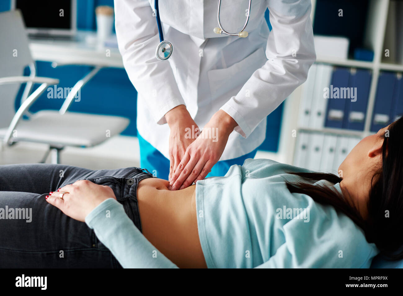 Doctor examining woman's stomach in medical practice Stock Photo - Alamy