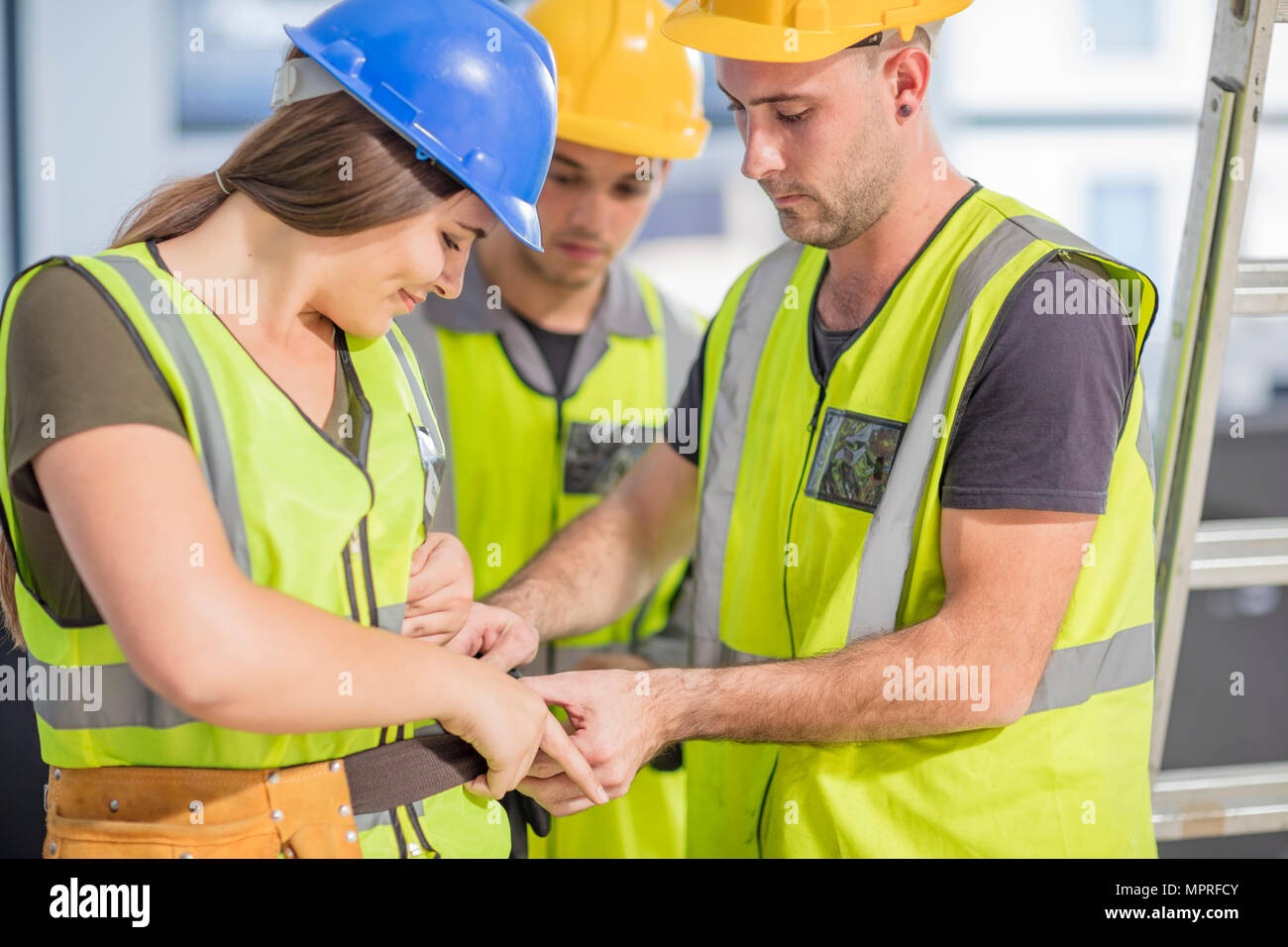 Construction worker helping colleague tool belt hi-res stock ...