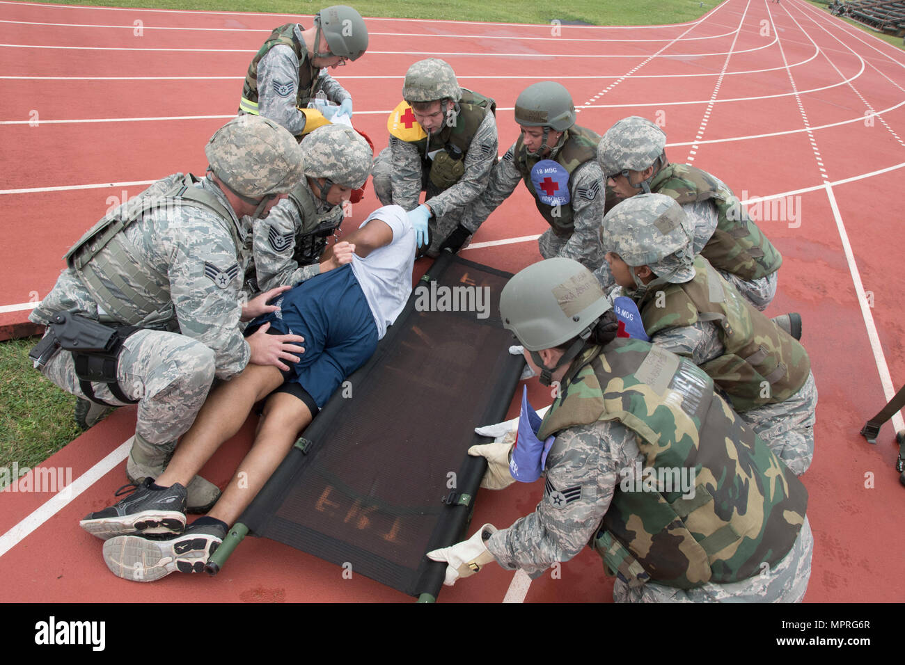 U.S. Air Force Airmen roll a simulated casualty onto a litter during a ...