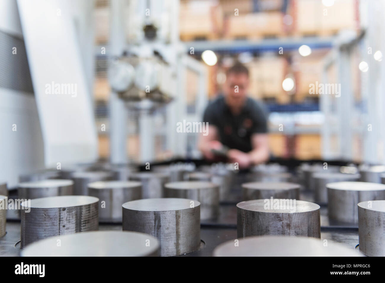 Machine in factory with man in background Stock Photo - Alamy