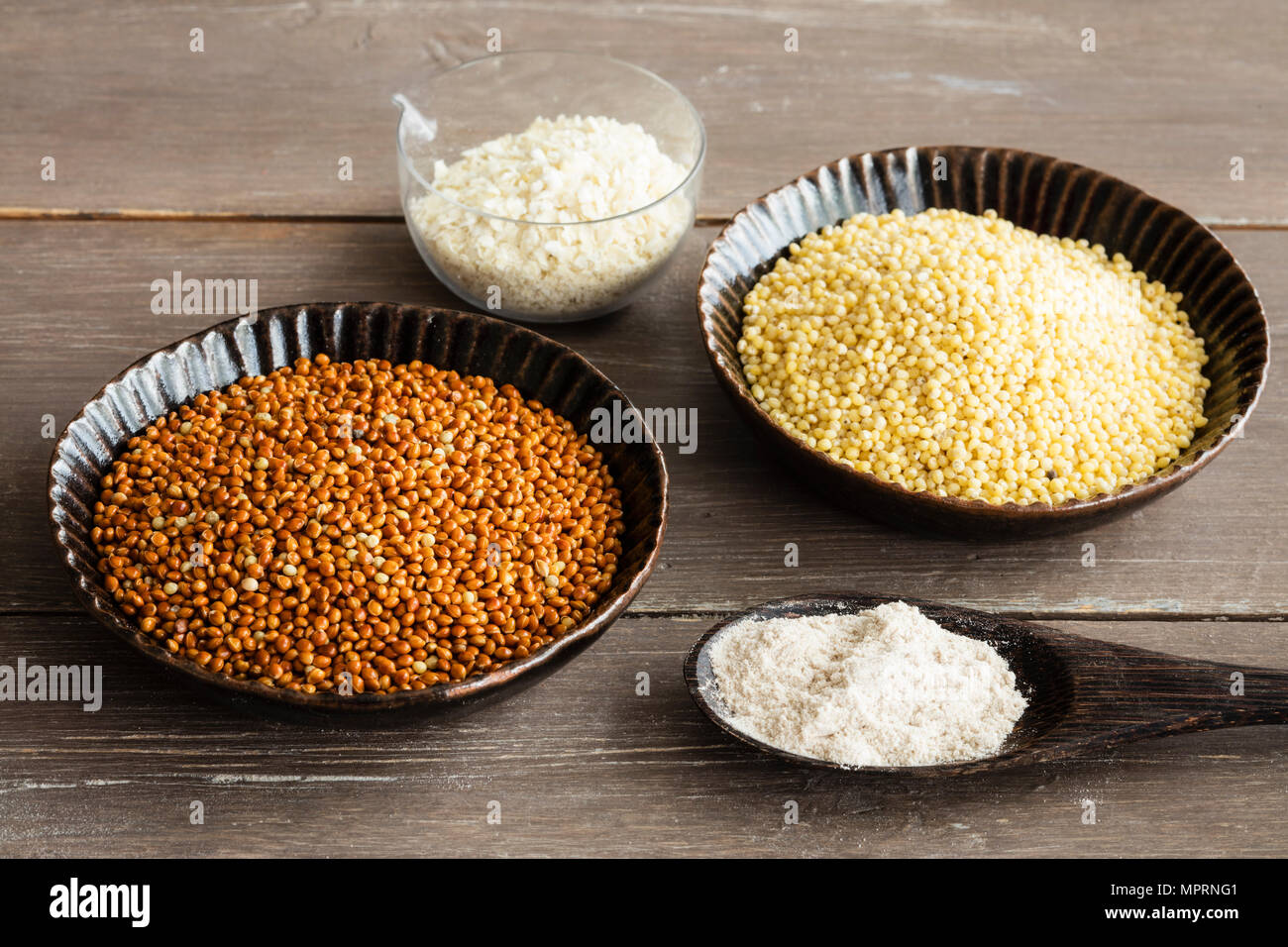 Spoons of Golden and brown millet, millet meal and millet flakes Stock ...