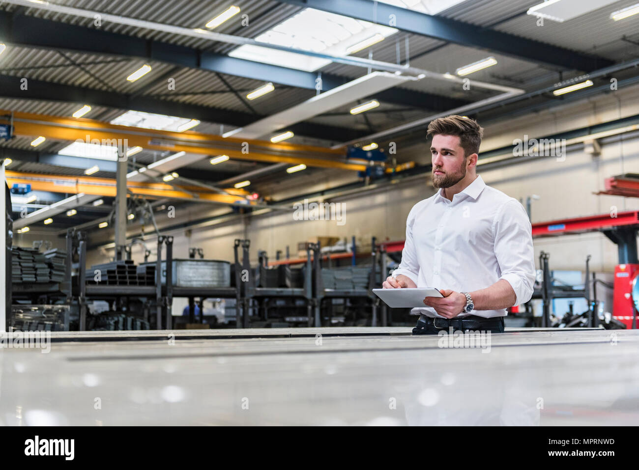 Man using tablet on factory shop floor Stock Photo - Alamy