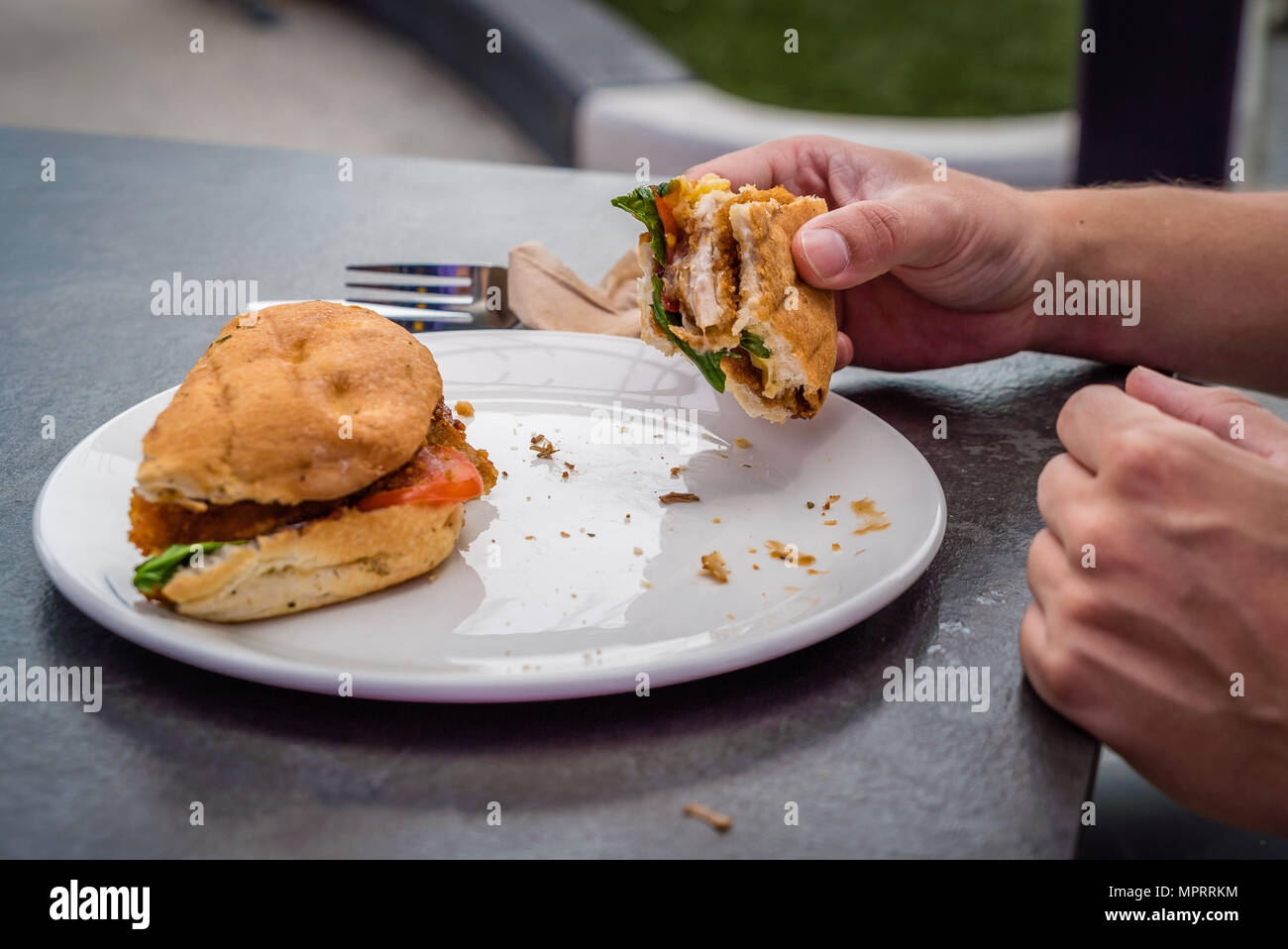 Someone eating a chicken burger for lunch in Australia Stock Photo - Alamy