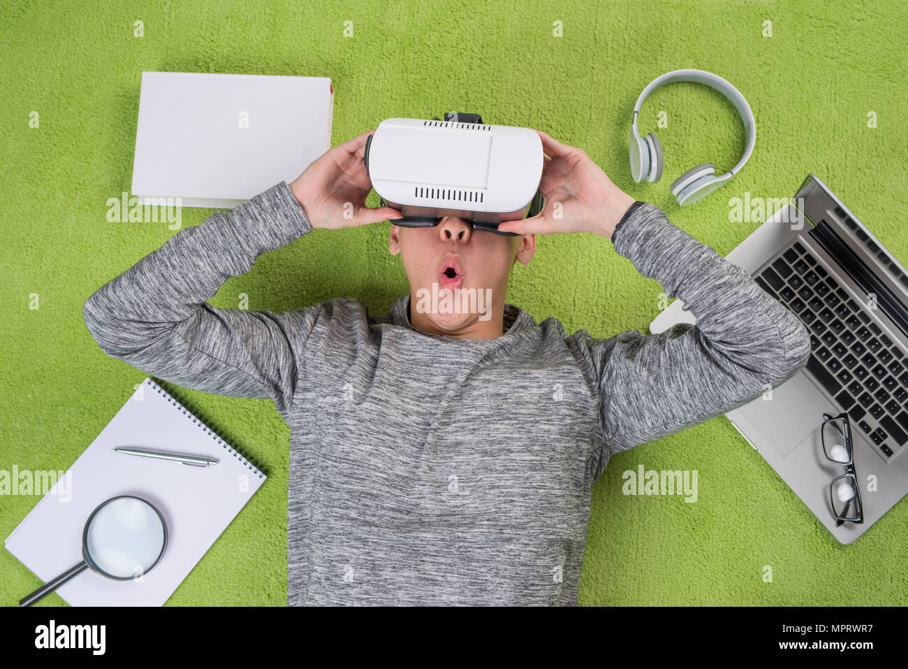 Top view of asian man wearing virtual reality goggles. Man lying on the ...