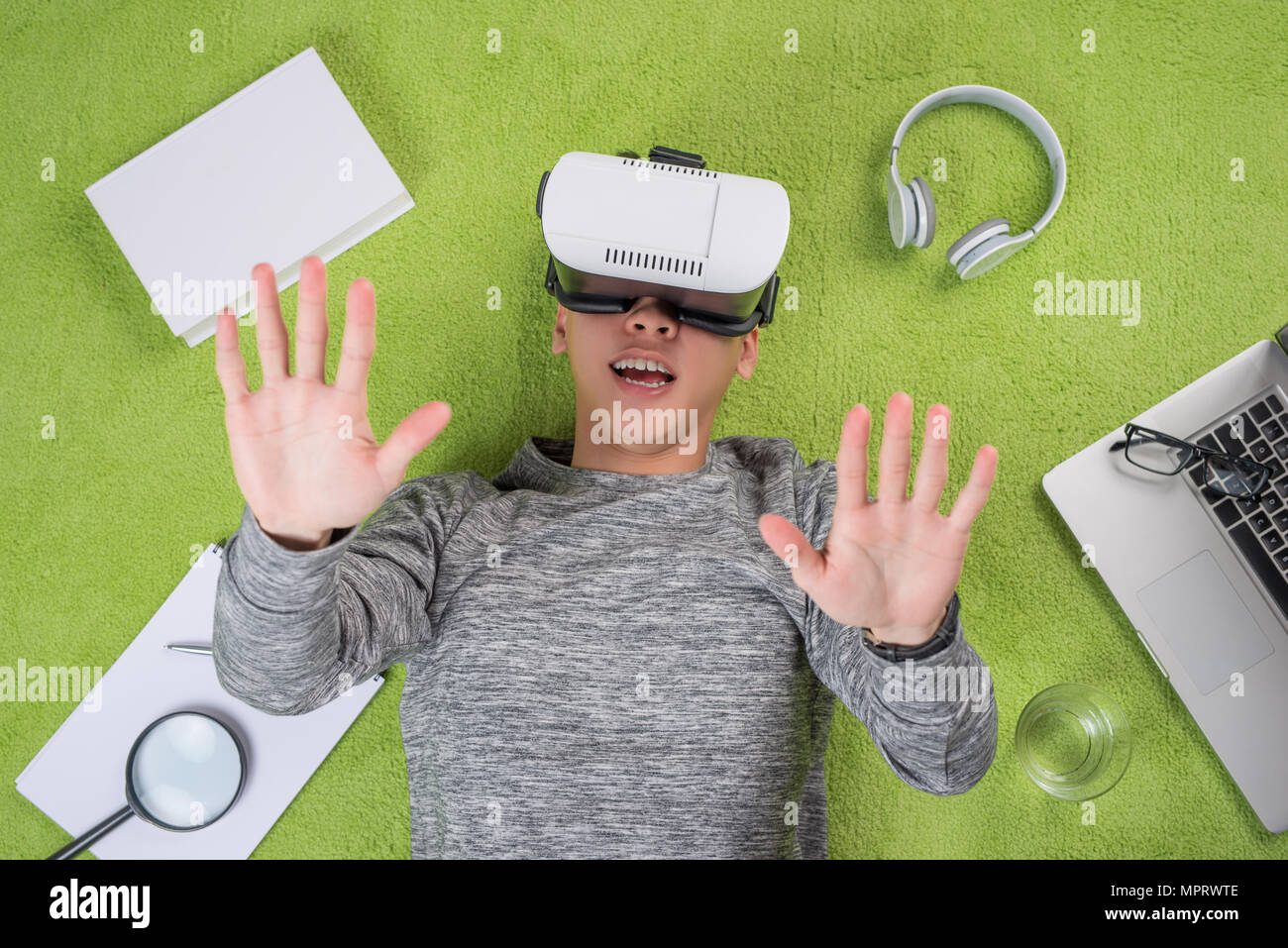 Top view of asian man wearing virtual reality goggles. Man lying on the ...