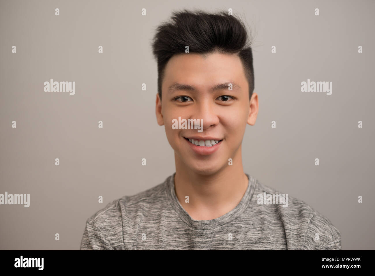 Portrait of good looking asian man over gray background Stock Photo - Alamy