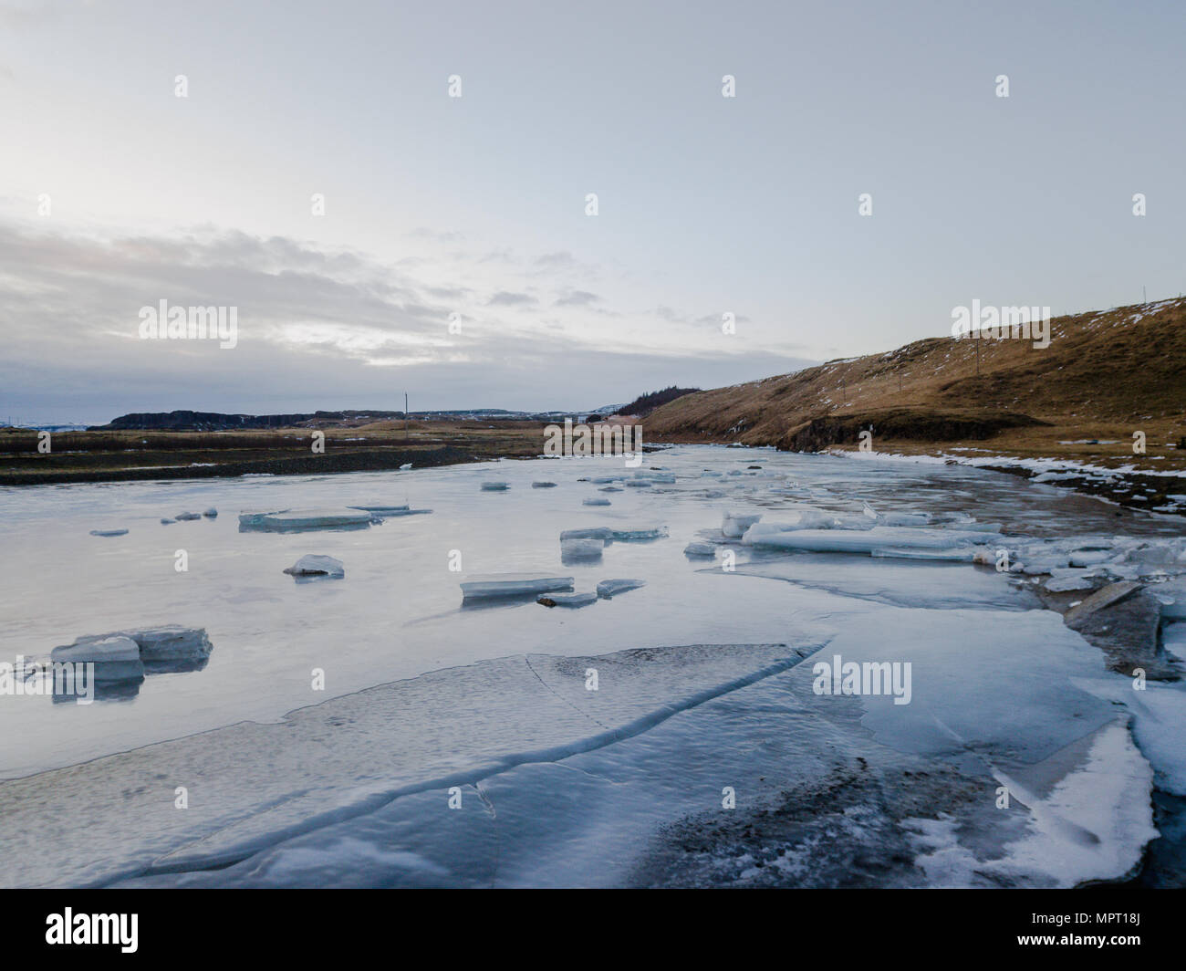 A frozen lake in Iceland with some hills in the background Stock Photo ...