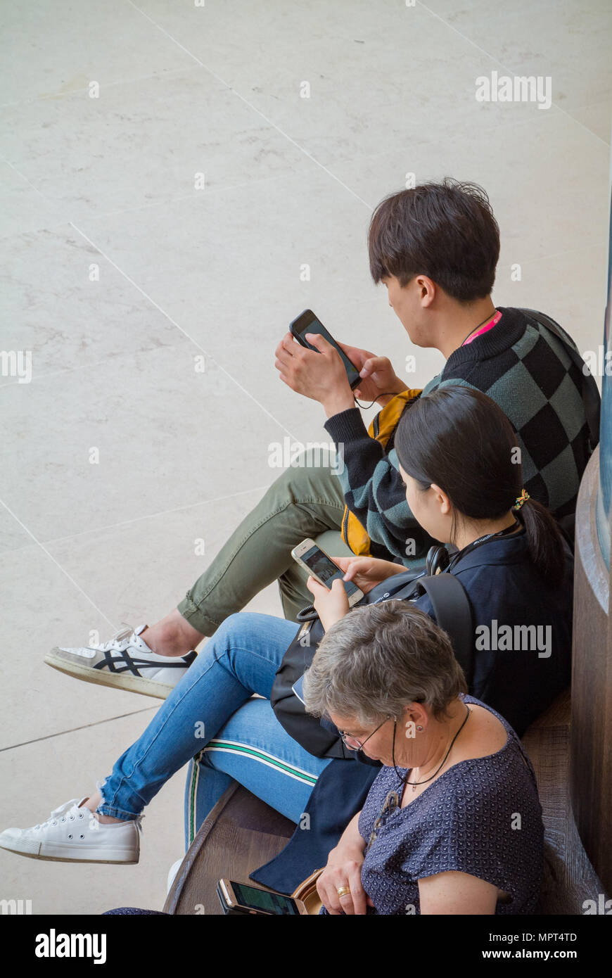 Sitting people using mobile phone, Paris, France Stock Photo - Alamy