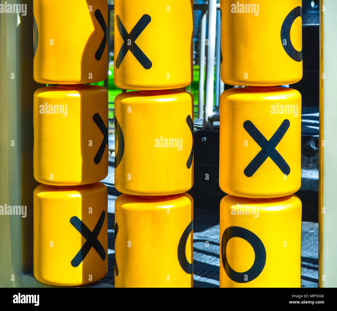 Rotating plastic yellow cylinders with a play of tic-tac-toe for ...
