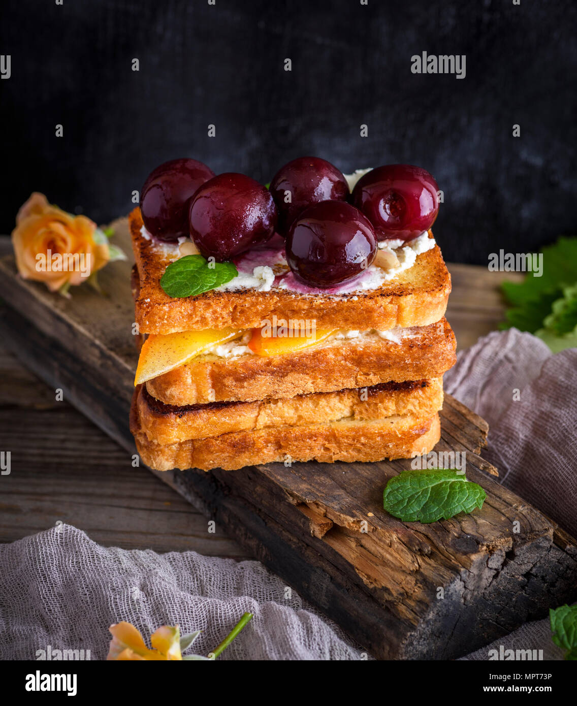 fried square pieces of white bread with soft curd and cherries on a ...