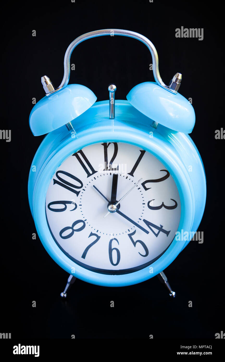 Blue alarm clock on black background Stock Photo - Alamy