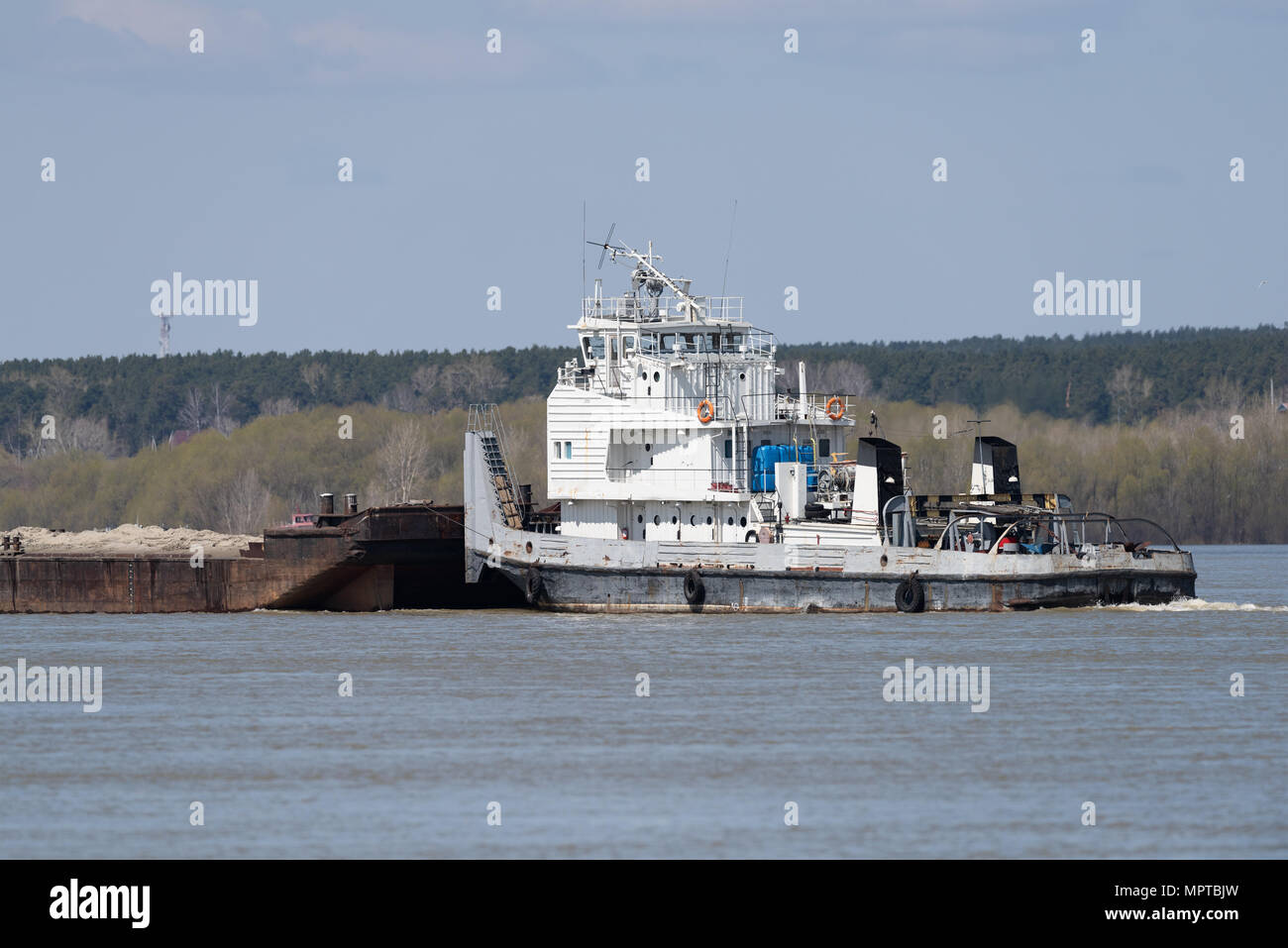The tug carries a barge with sand Stock Photo - Alamy