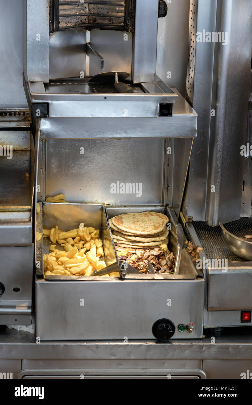 Gyro meat, French fries and tortillas in Greek gyros shop. Grilled meat ...