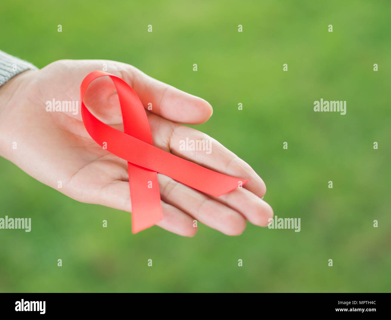 Closeup female hands holding red ribbon HIV, world AIDS day awareness ...