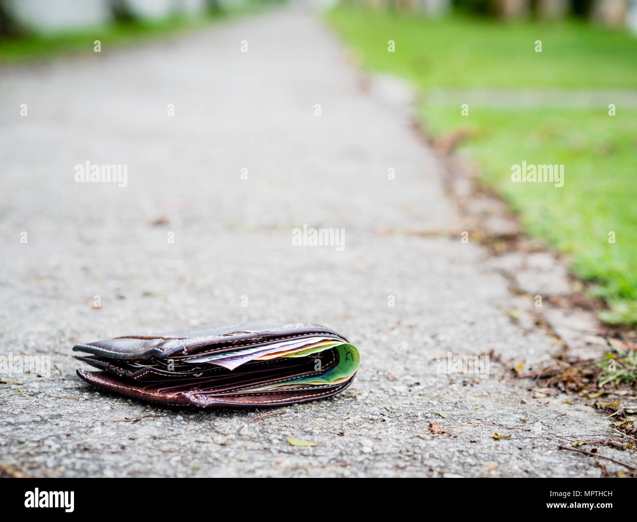 Lost leather wallet with money drop on sidewalk , lost money concept ...