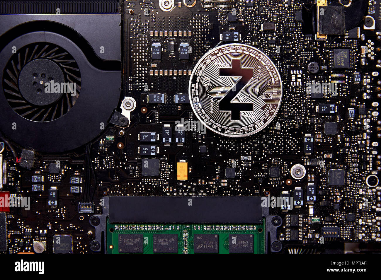 A ZCash physical coin sitting on a computer motherboard with a fan and ...