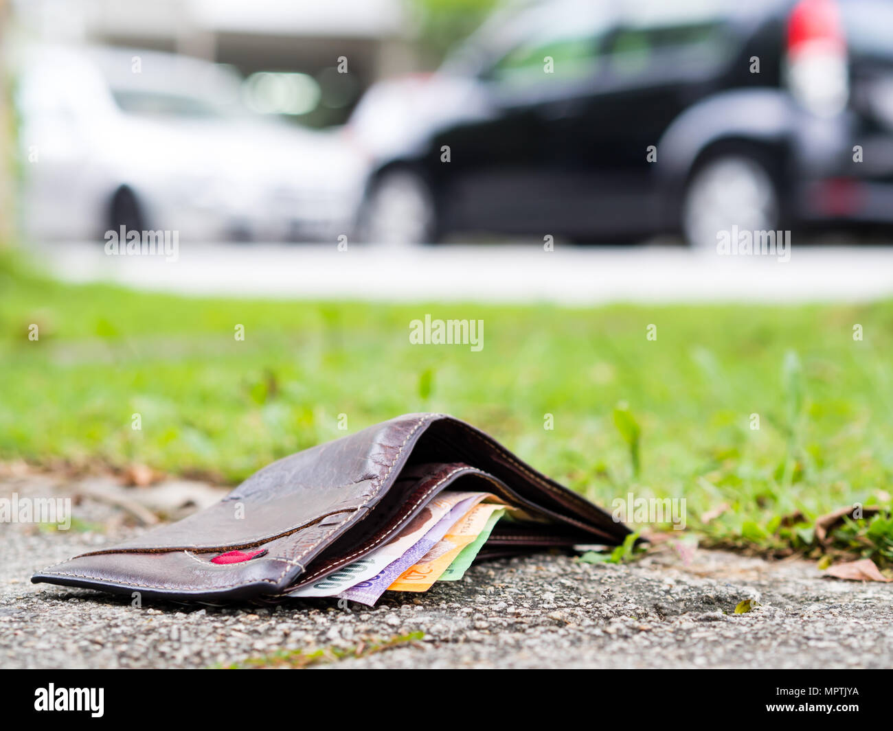 Lost leather wallet with money drop on sidewalk , lost money concept ...