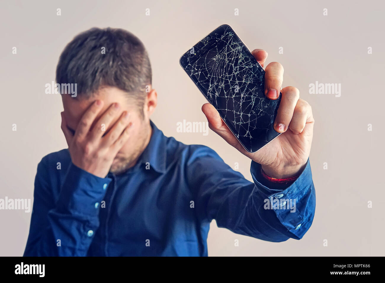 The guy is holding a black smartphone with a broken display. Broken ...