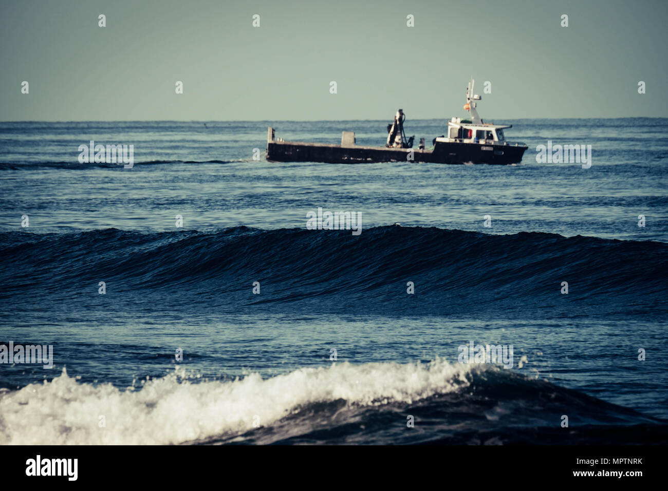 Boat in the waves in the ocean of Tenerife. Bad sea with big waves and ...