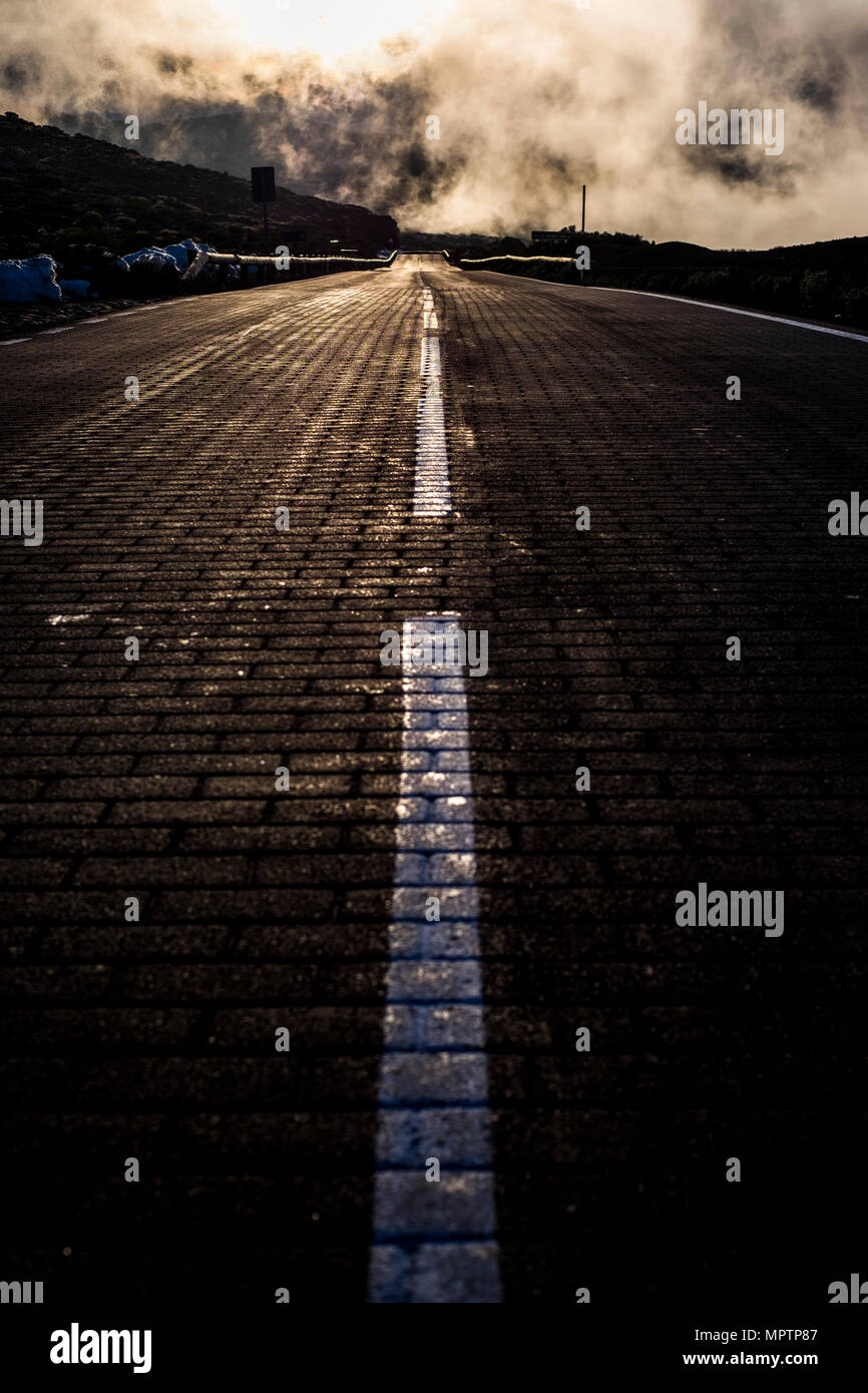 ground point of view for a black asphalt road long one with white line ...