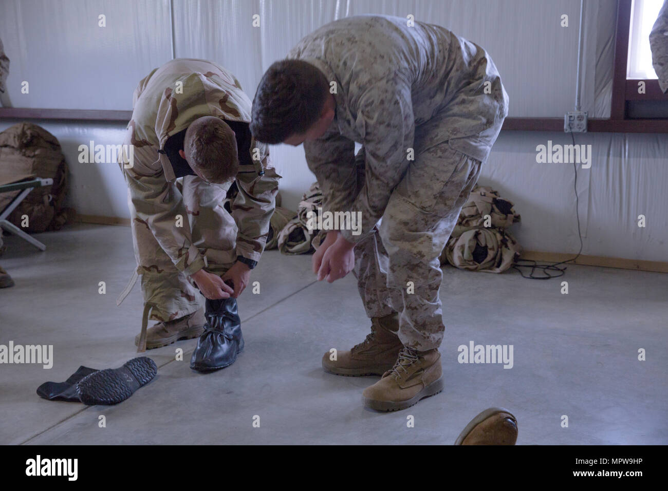 Cpl. Brandon Smith, right, instructs a Marine on the proper way to put ...