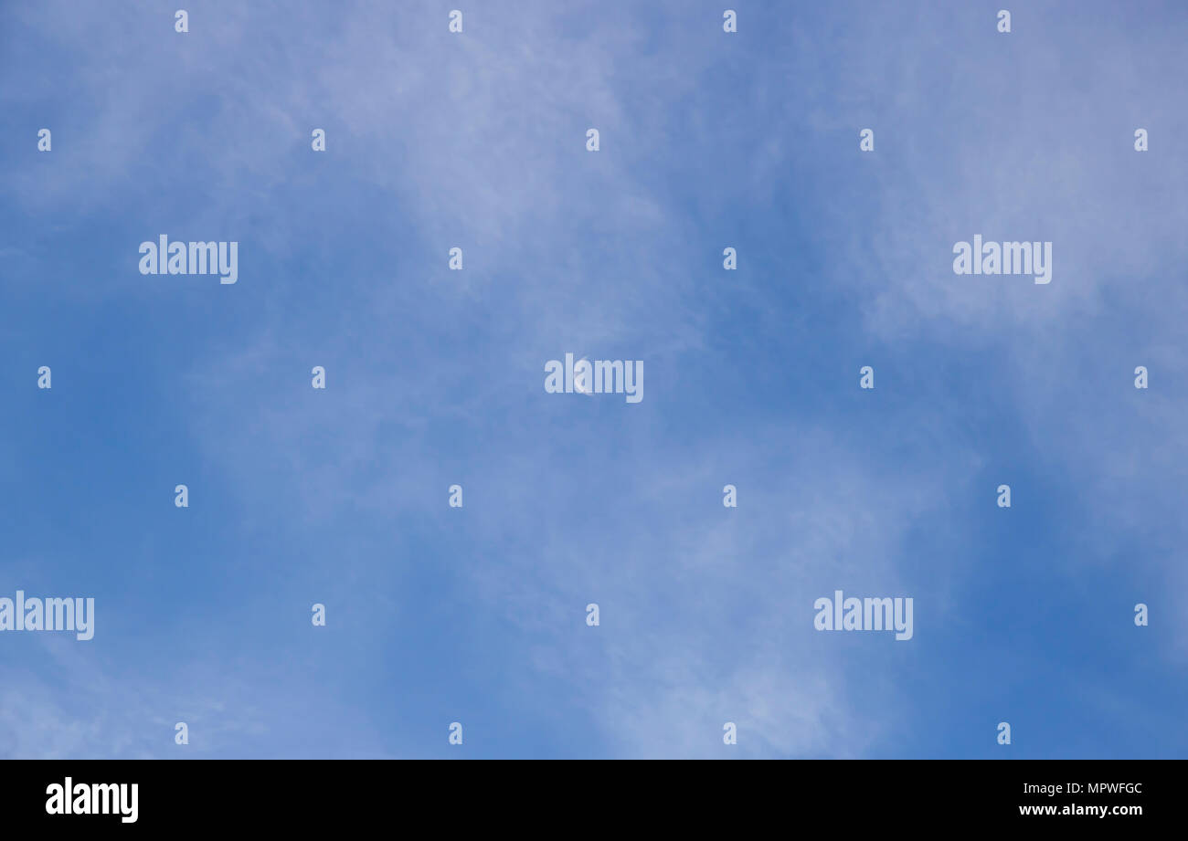 small month in blue sky with sparse clouds Stock Photo - Alamy