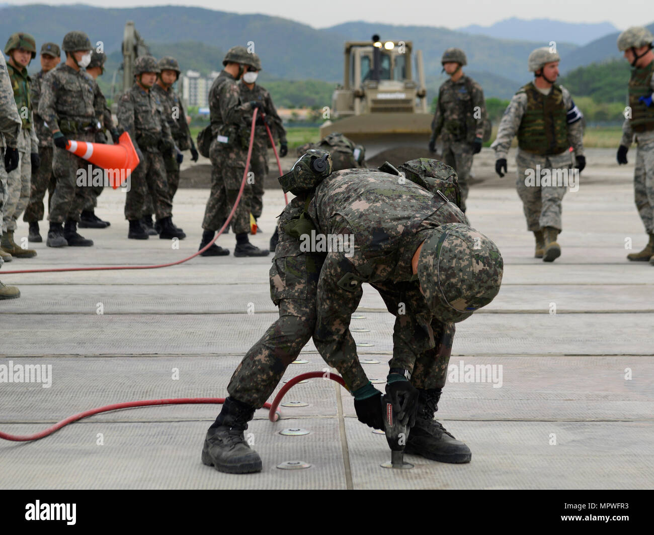 A Republic of Korea Airman secures a rapid-runway repair fiberglass mat ...