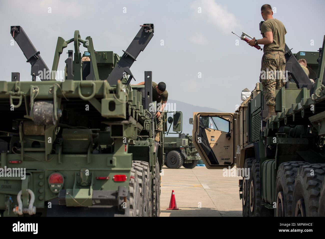 U.S. Marines with Combat Logistics Regiment 35, 3D Marine Logistics Group, inspect a vehicle as ...