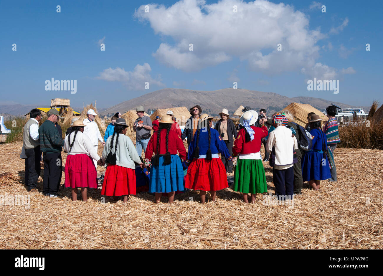 Local Uros with tourists in a spiritual prayer circle, Lake Titicaca ...