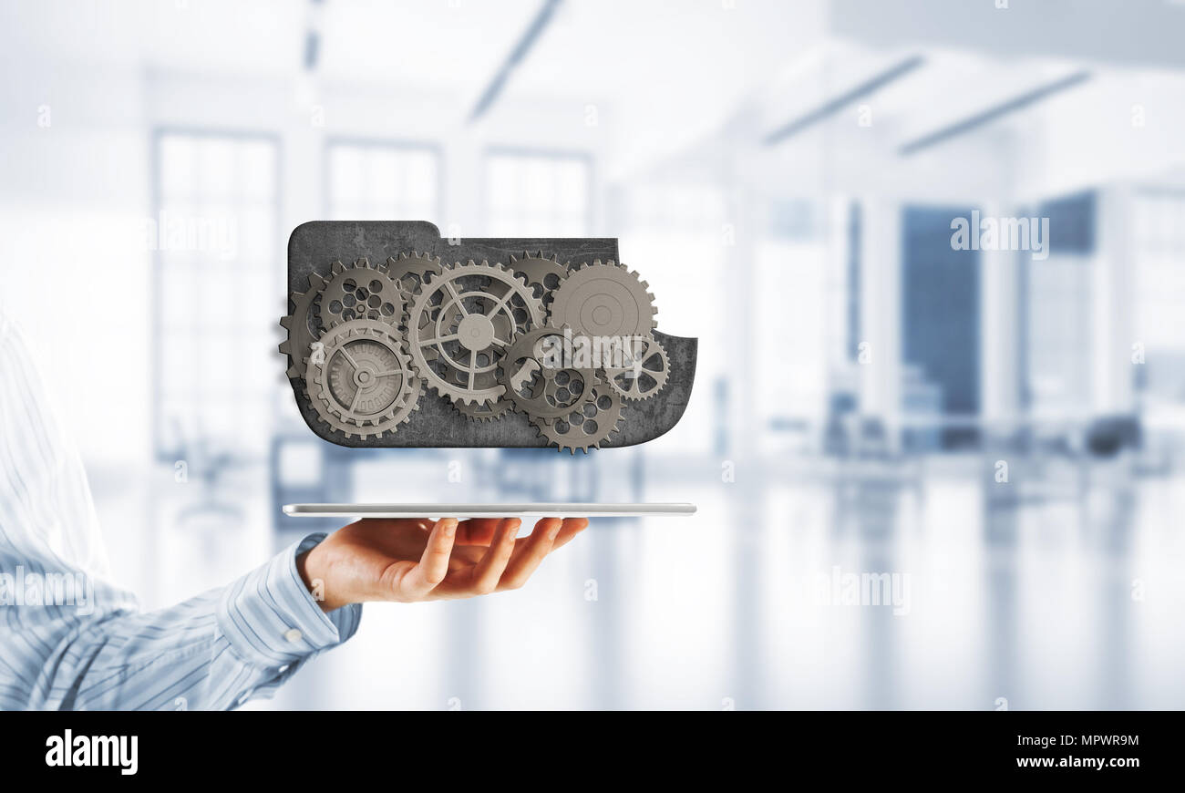 Close of businessman holding tablet pc with engine presenting teamwork ...