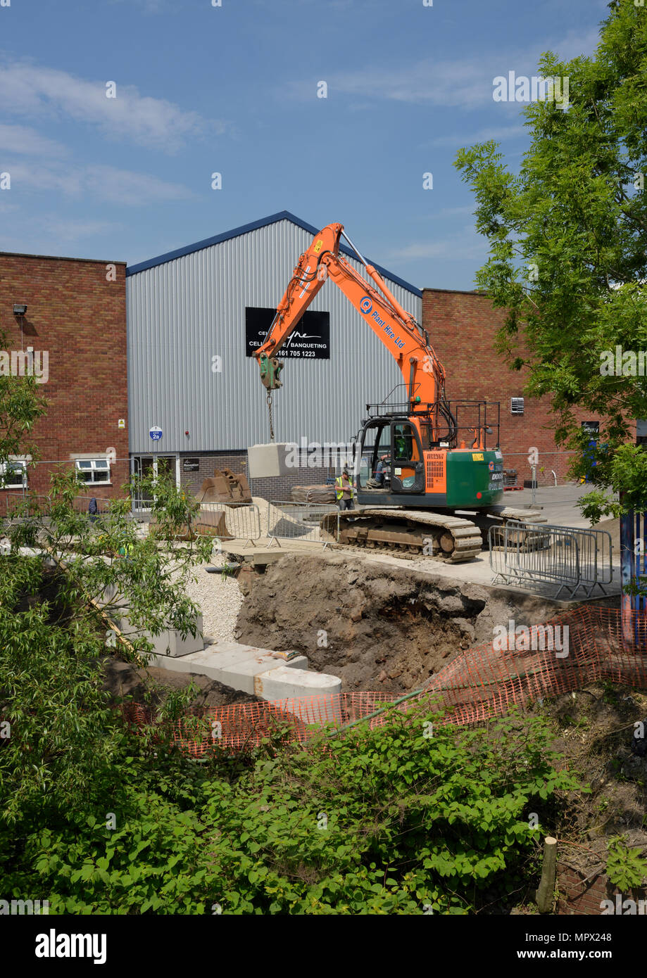 360 tracked hydraulic excavator lifting concrete blocks onto new flood ...