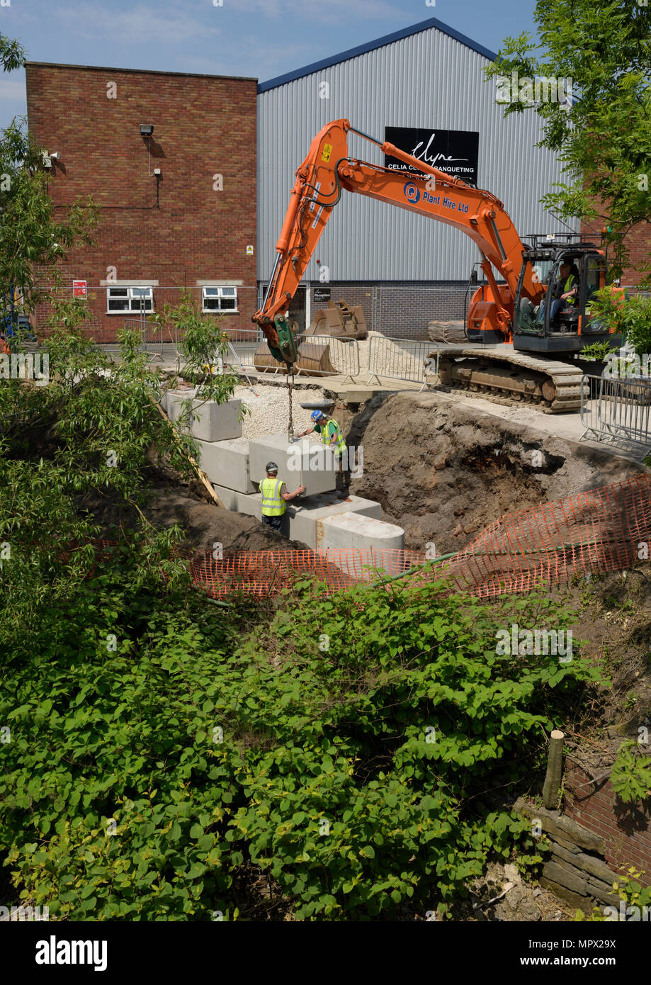 360 tracked hydraulic excavator lifting concrete blocks onto new flood ...
