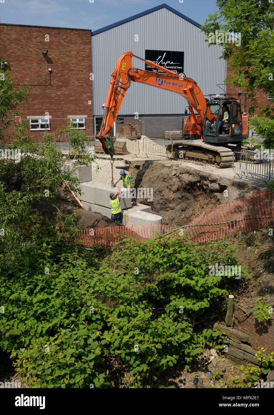 360 tracked hydraulic excavator lifting concrete blocks onto new flood ...