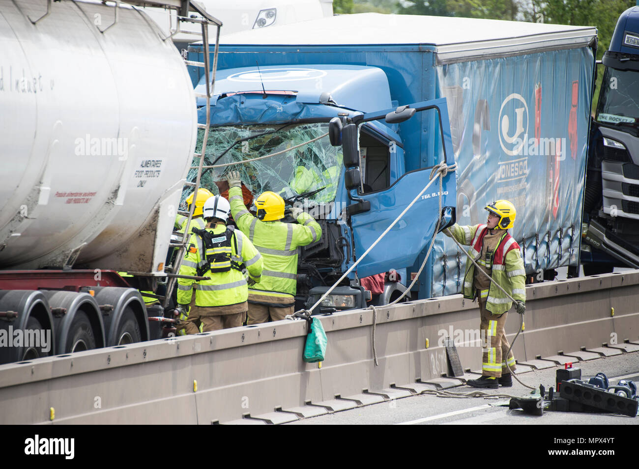 Four HGVs crash one man trapped fire service and ambulance crews trying to extracate him air ...